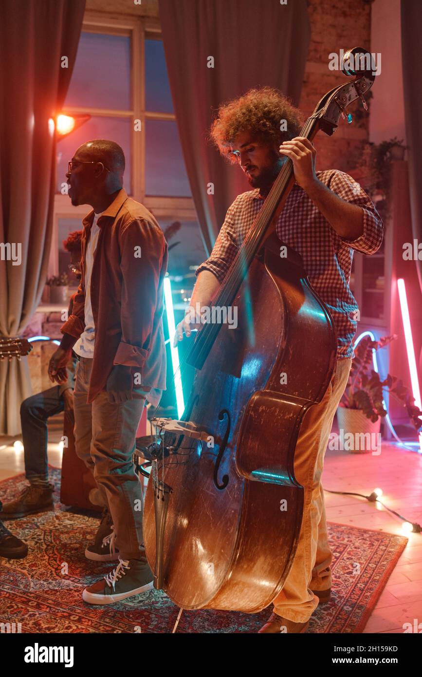 African young man singing while his colleagues playing musical ...