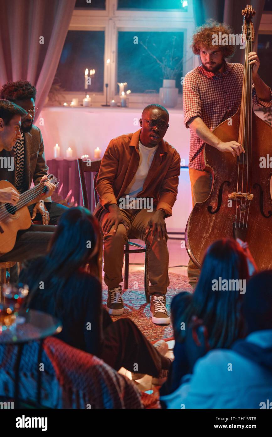 Young men performing in night club for people they singing and playing ...