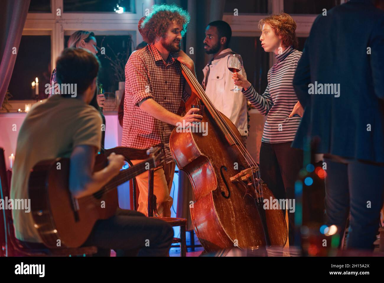 Music band of young guys playing on musical instruments during social ...