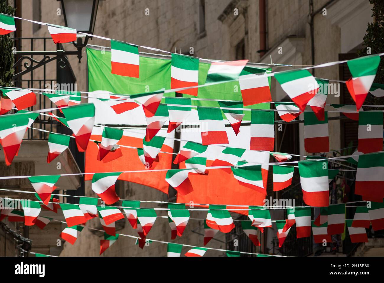 Italian flags and pennants in an old town narrow street of a city in ...
