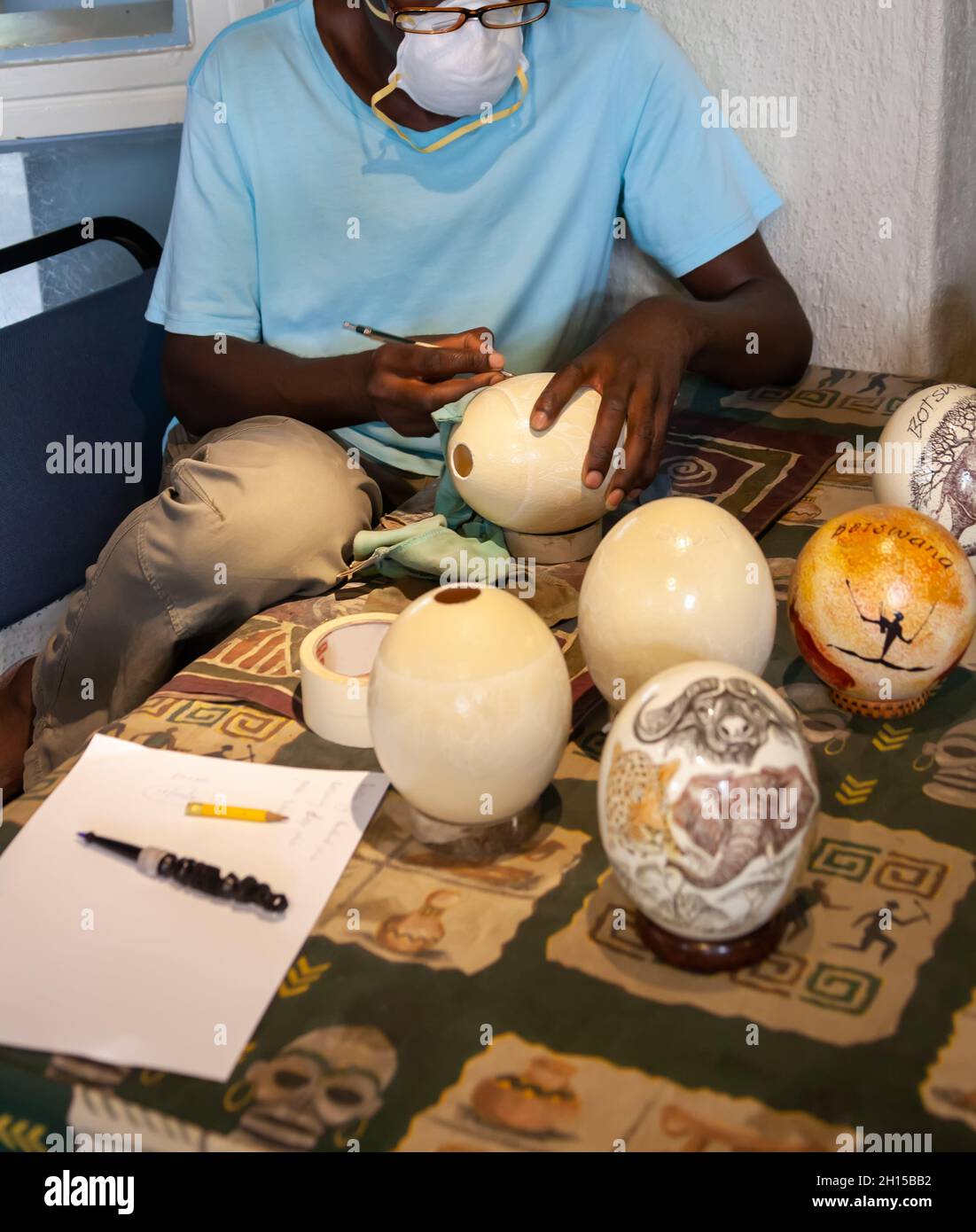 African craftsman carving sculpting few ostrich eggs by hand Stock ...