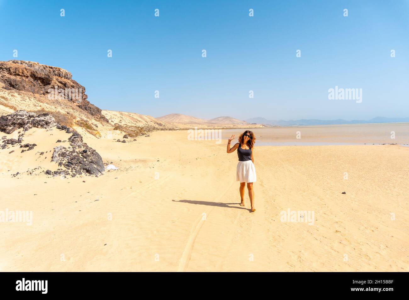 Young Spanish woman walking on Sotavento beach in the morning ...