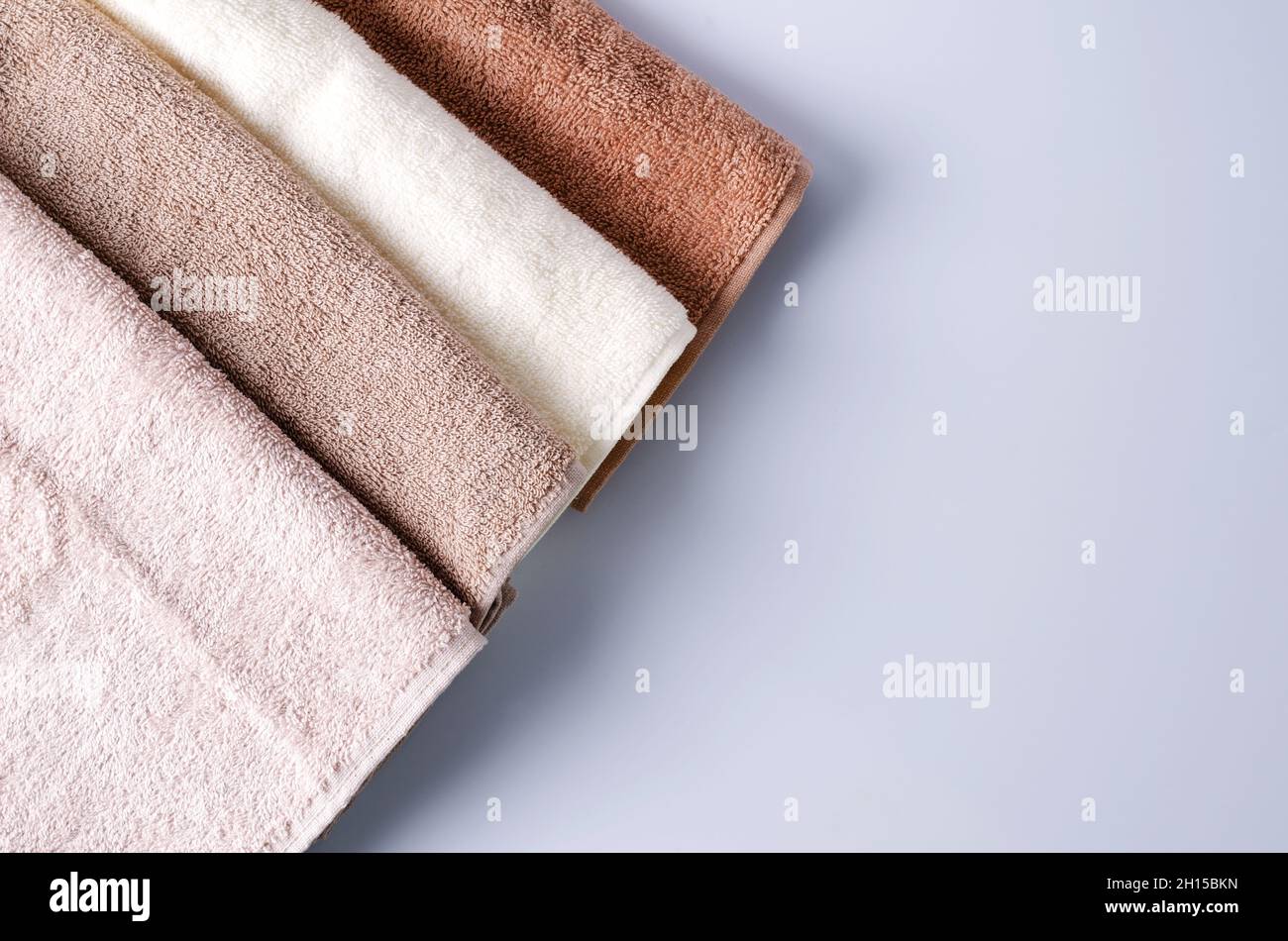 Cotton towels of different colors on a light background. Layout for ...
