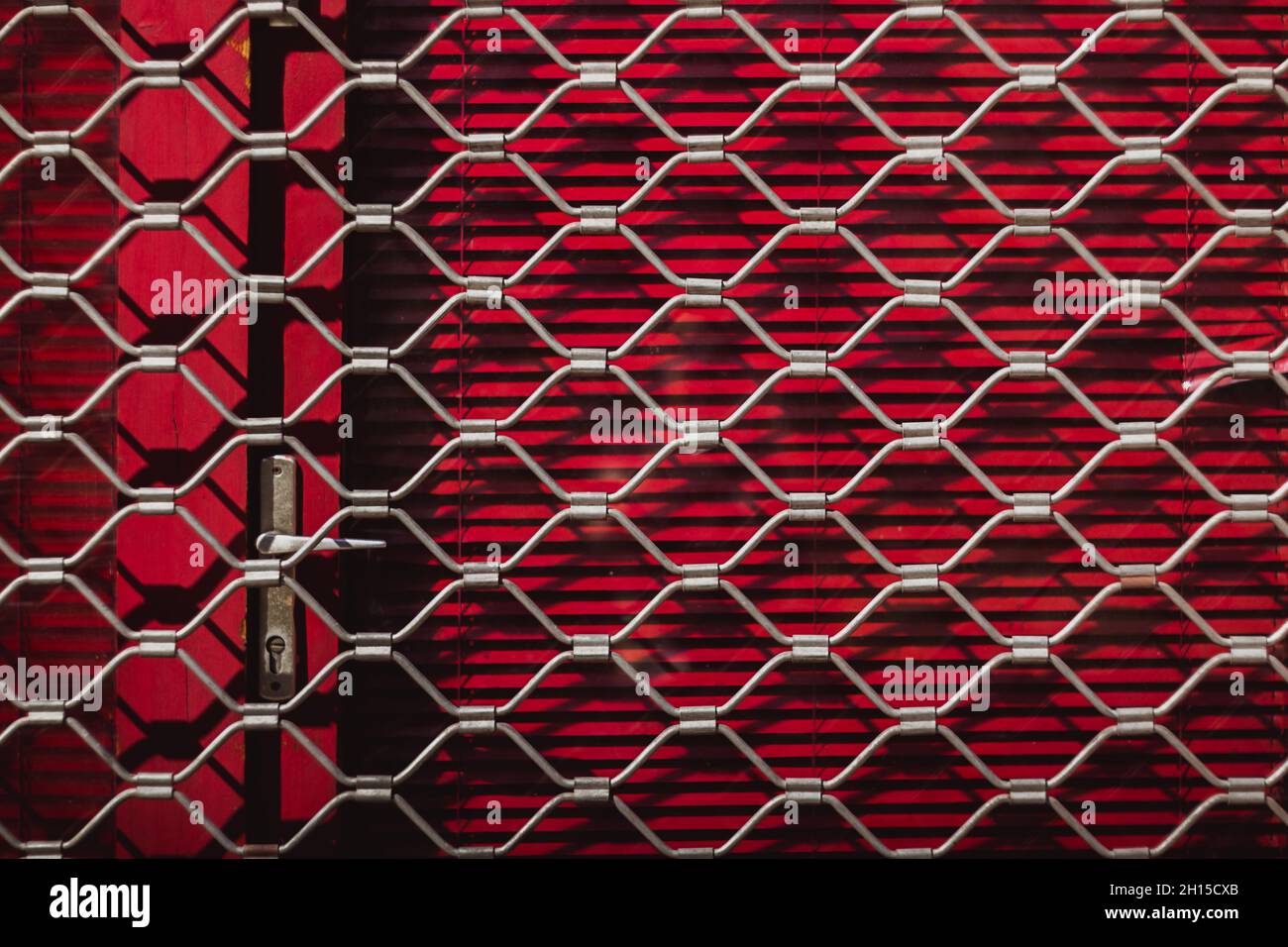 Iron texture of a steel grill on red shutters on the door. Red ...
