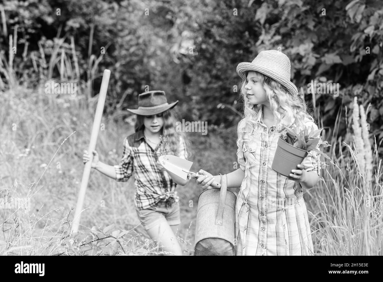 Sisters helping at farm. Girls with gardening tools. Eco farming ...