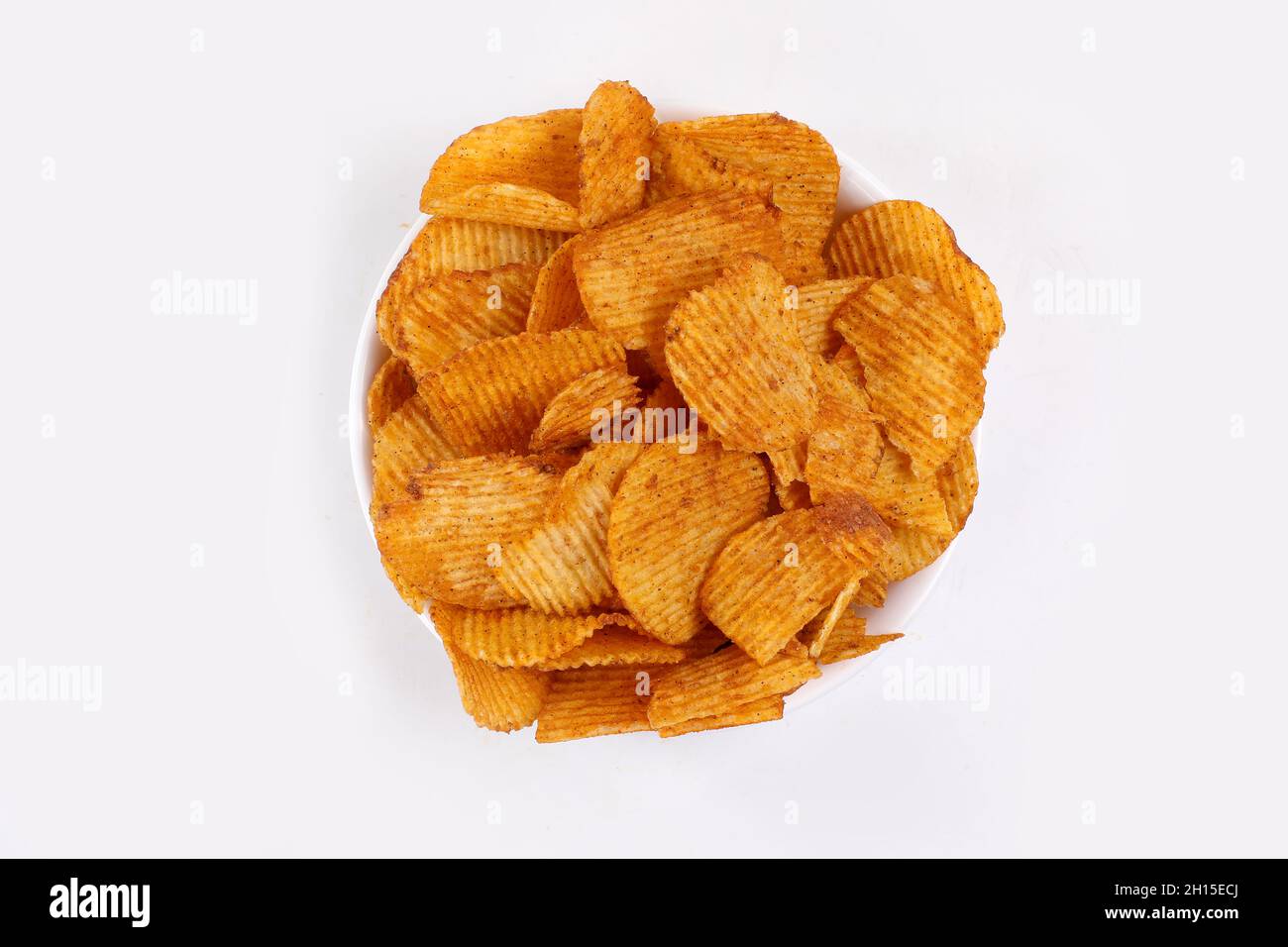 Potato chips falling into glass bowl isolated on white background with ...