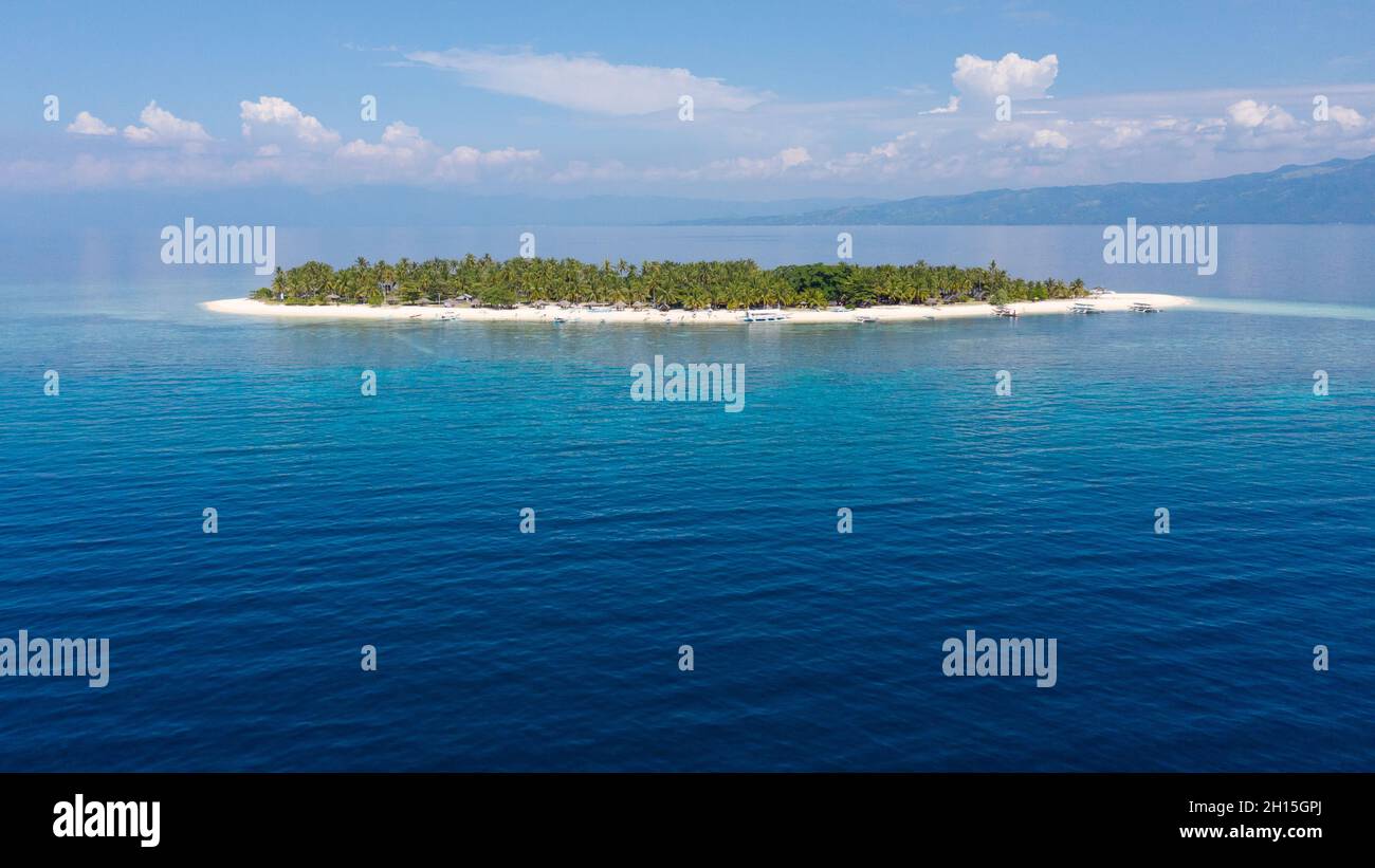 Tropical island. A small island with a white sandy beach and palm trees ...