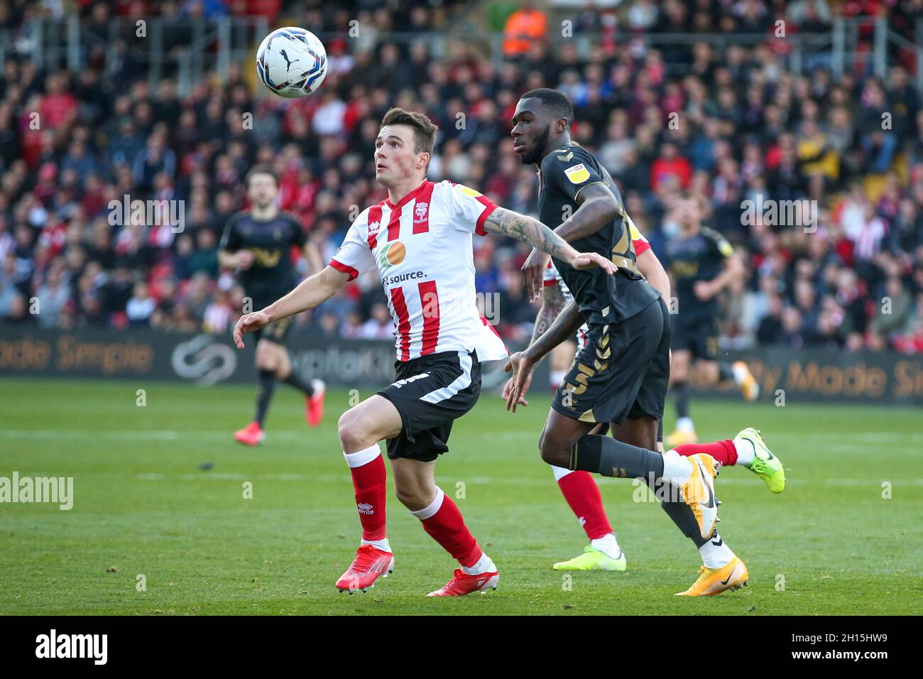 LINCOLN, UK. OCT 16TH Jamie Robson of Lincoln City battles Corey ...