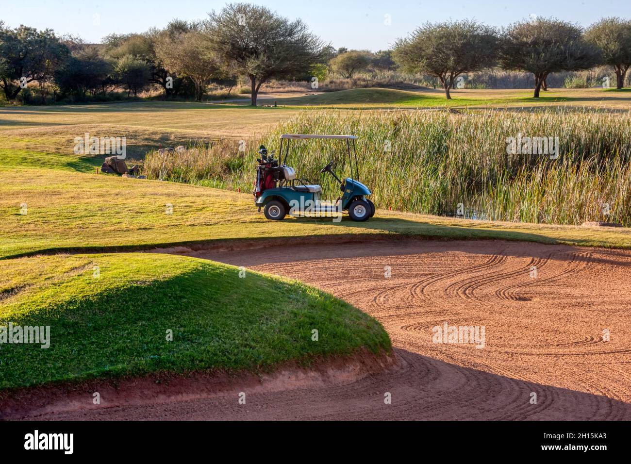 Golf cart in the field loaded with equipment clubs Stock Photo - Alamy