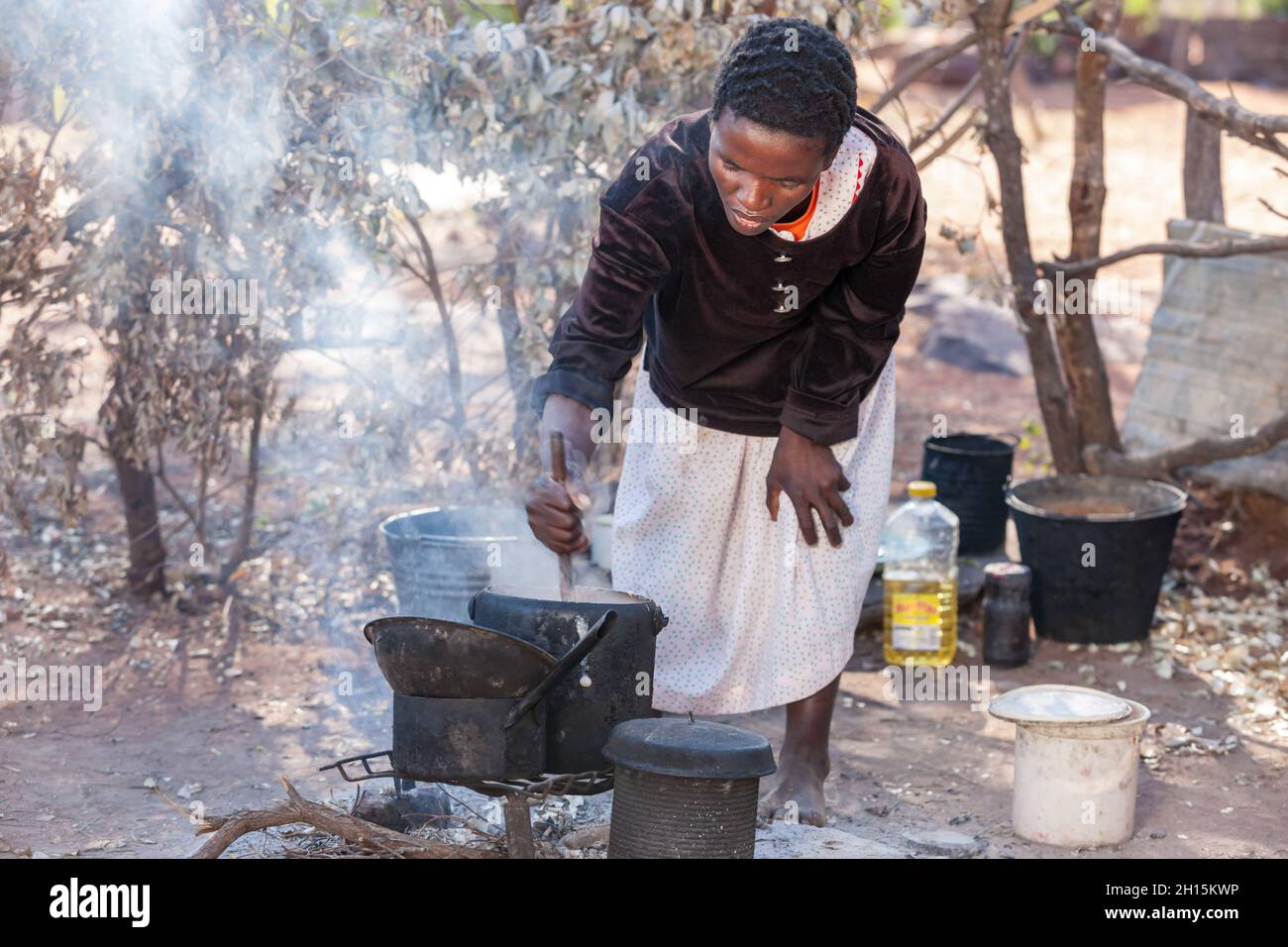 Outdoors kitchen, African woman cooking pap and Setswa is a traditional ...