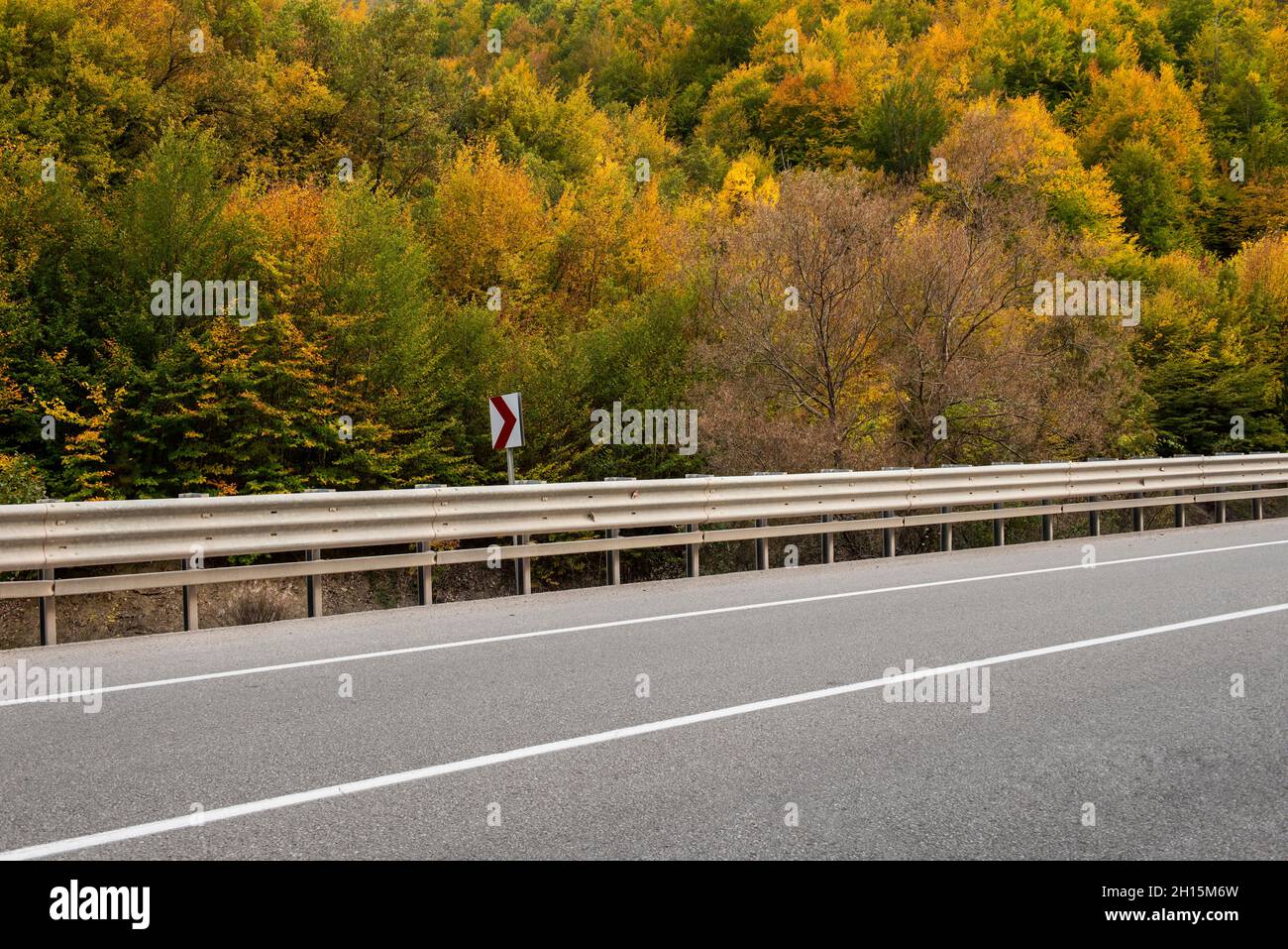 Highway and autumn landscape with vibrant fall colors. Empty mountain ...