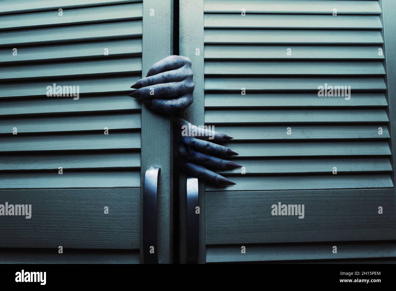 Horror blue toned cupboard doors with scary female monster hands ...