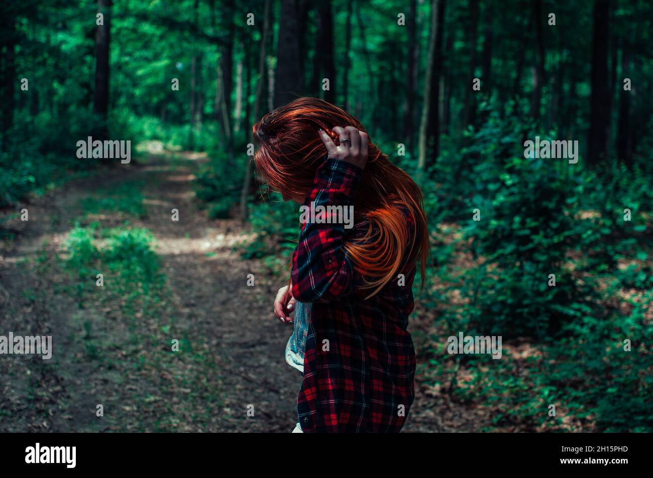 Ginger female standing and posing in a green forest Stock Photo - Alamy