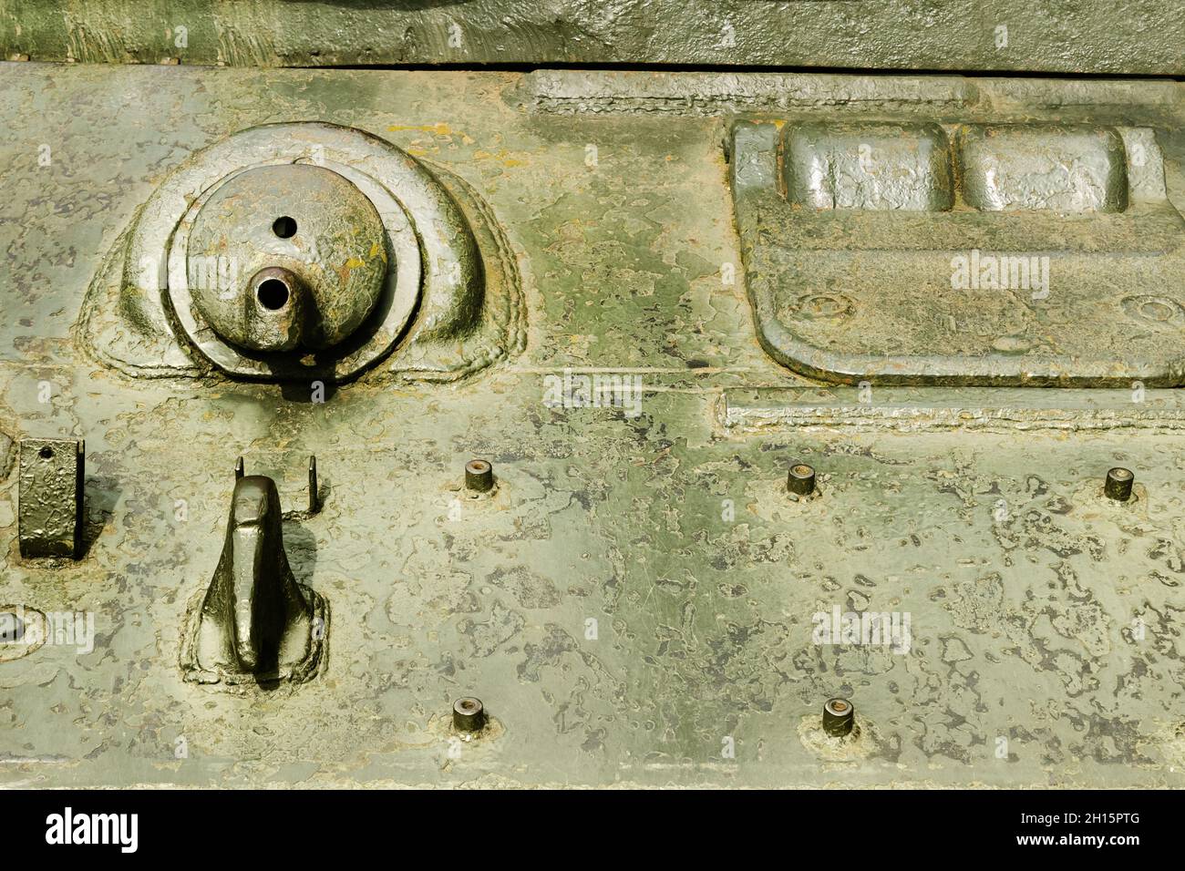 Photo of old and rusty green colored military vehicle armored surface with mechanical parts ...