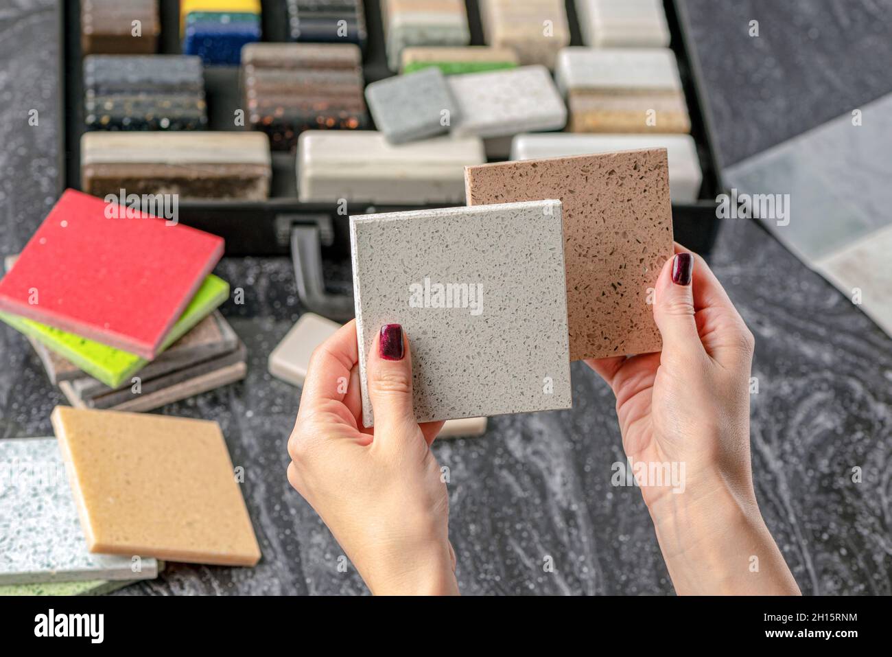 Choice of tiles. Female hands hold samples of tiles of different colors ...