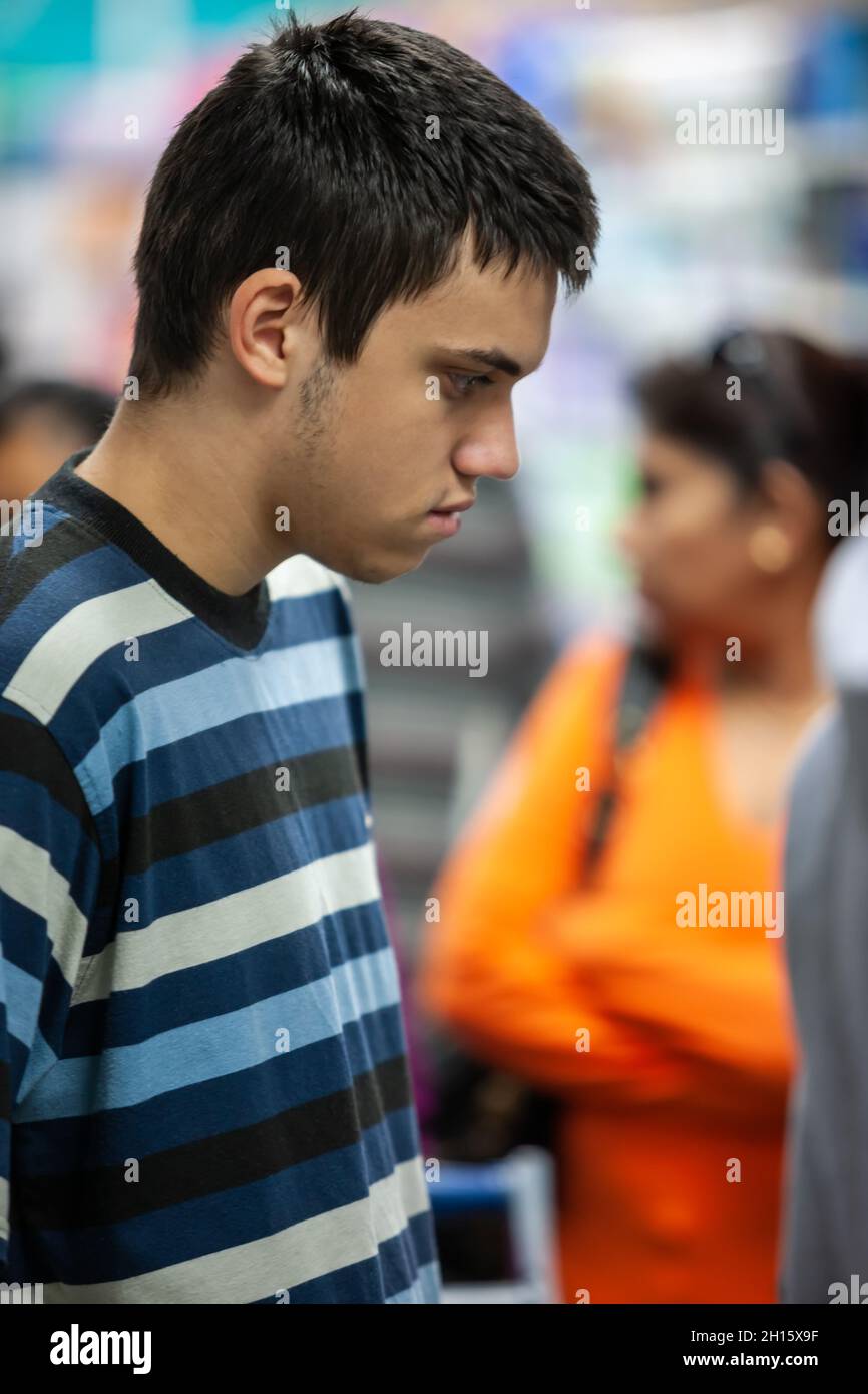 Young Caucasian man in a crowd of African people in a Modern shopping ...