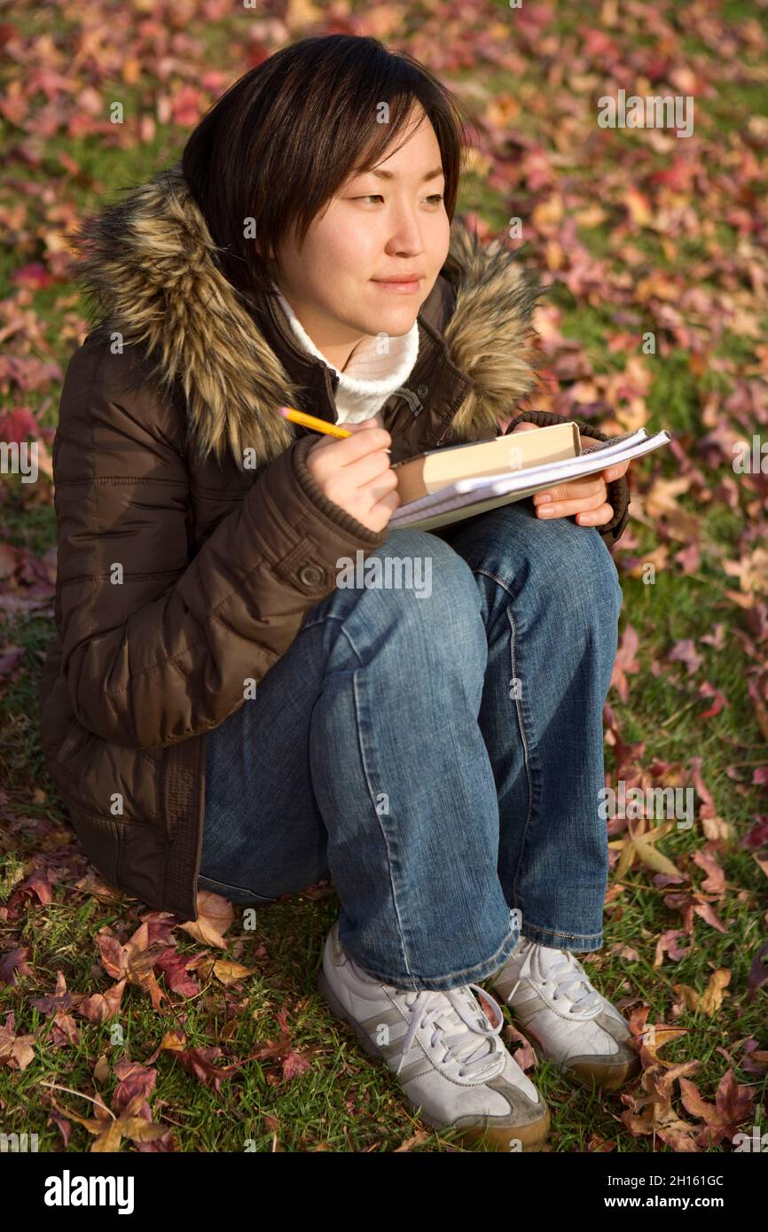 A young woman student studies on campus in Autumn Stock Photo - Alamy