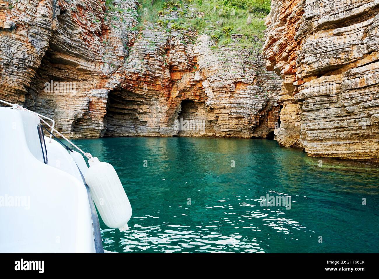Small boat explore exotic lagoon with mountains and caves. Tropical ...