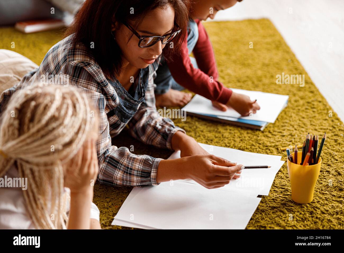 Children and teacher drawing together at school Stock Photo - Alamy
