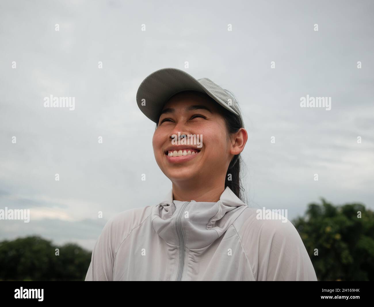 Female runners in a hat prepares for jogging outdoors. Athlete enjoying ...