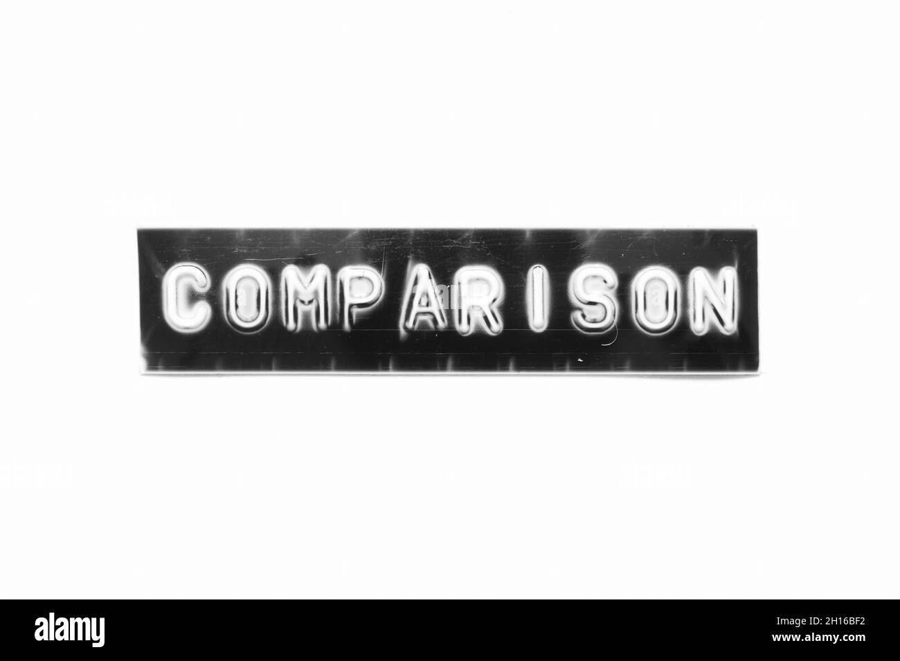 Embossed letter with word comparison in black banner on white paper ...