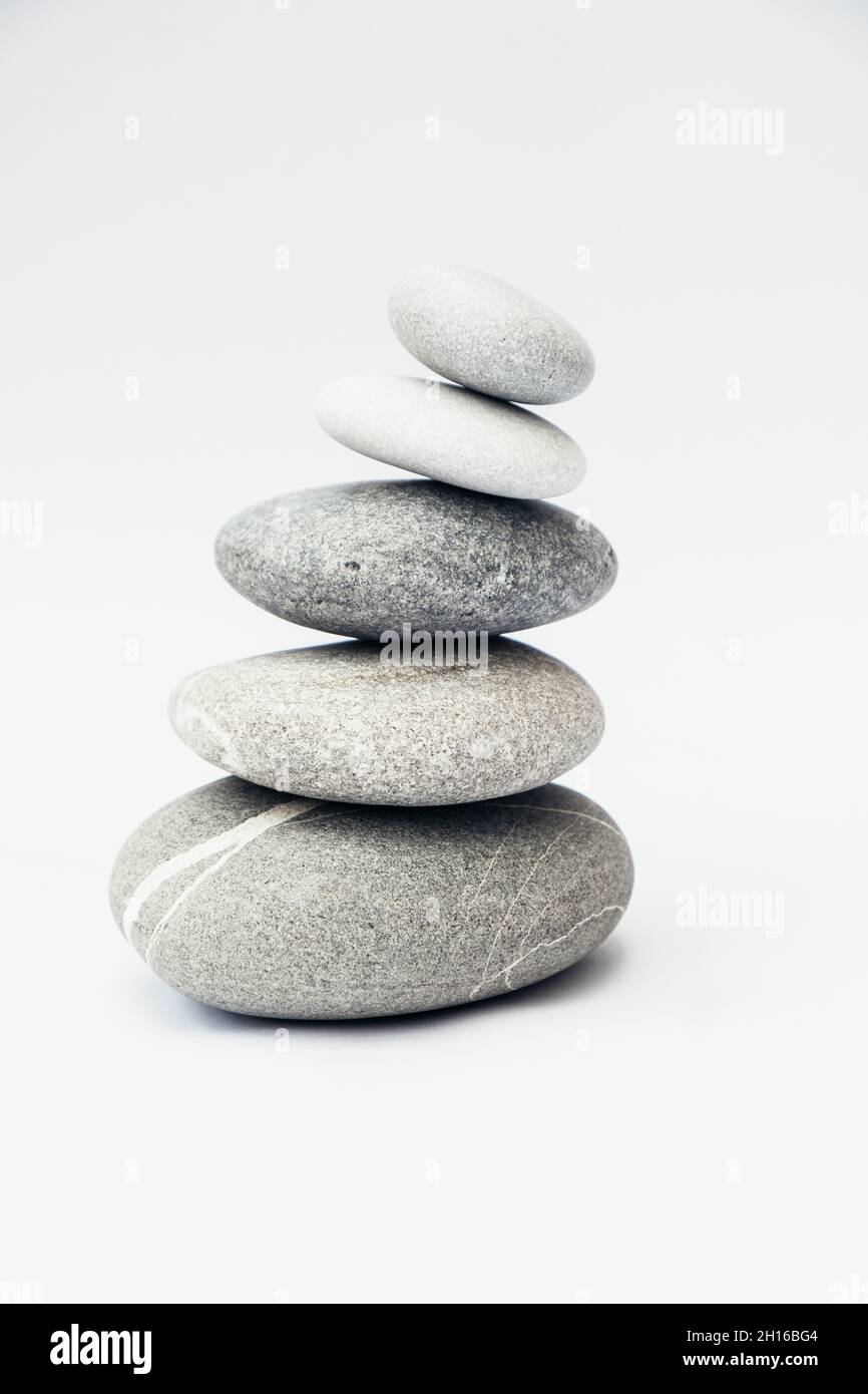 Stone cairn on light background, stones tower, simple poise stones. Purity harmony and Balance ...
