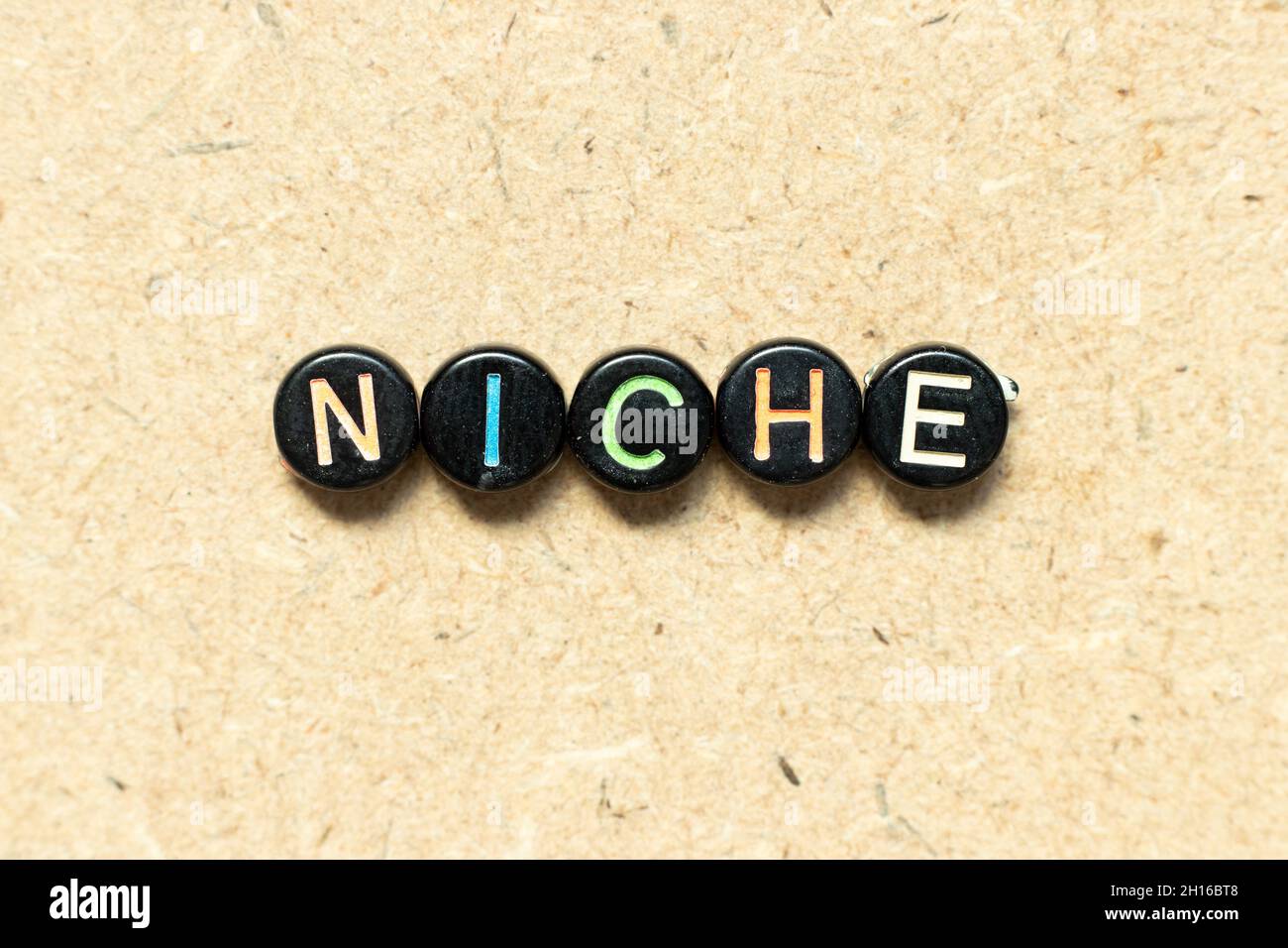 Black color round bead in word niche on wood background Stock Photo - Alamy