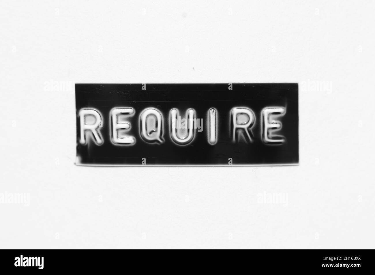 Black color banner that have embossed letter with word require on white ...