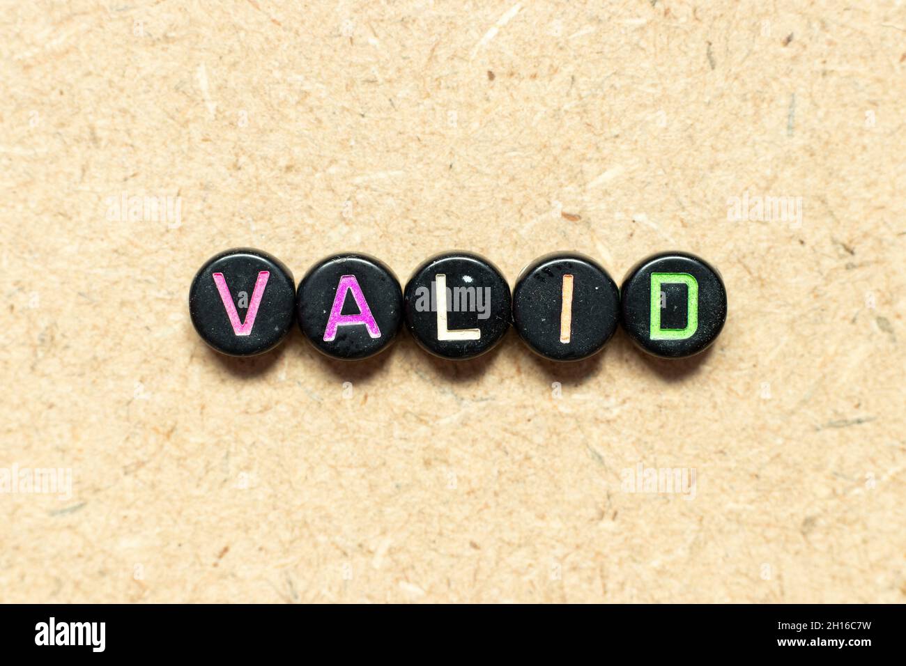 Black color round bead in word valid on wood background Stock Photo - Alamy