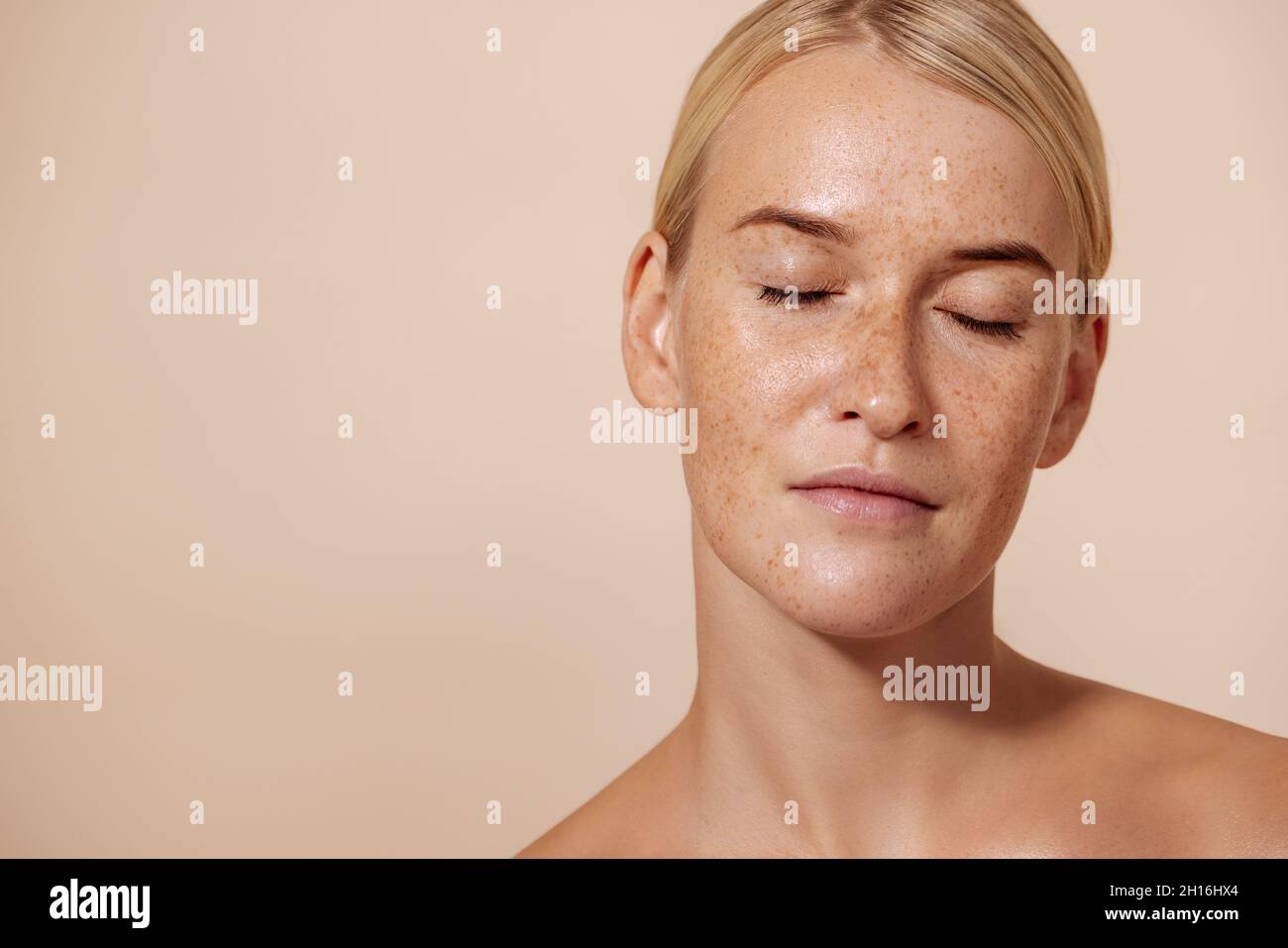 Portrait of a beautiful woman with perfect skin standing with closed ...