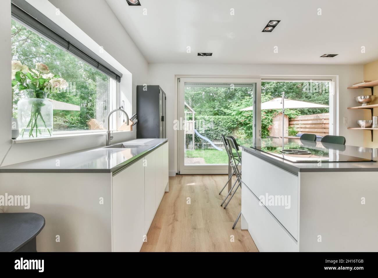 Kitchen counter with chairs placed in spacious dining room with window ...