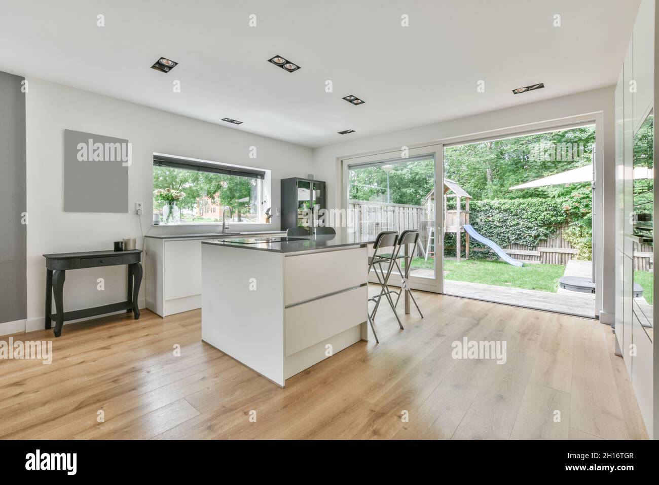 Kitchen counter with chairs placed in spacious dining room with window ...