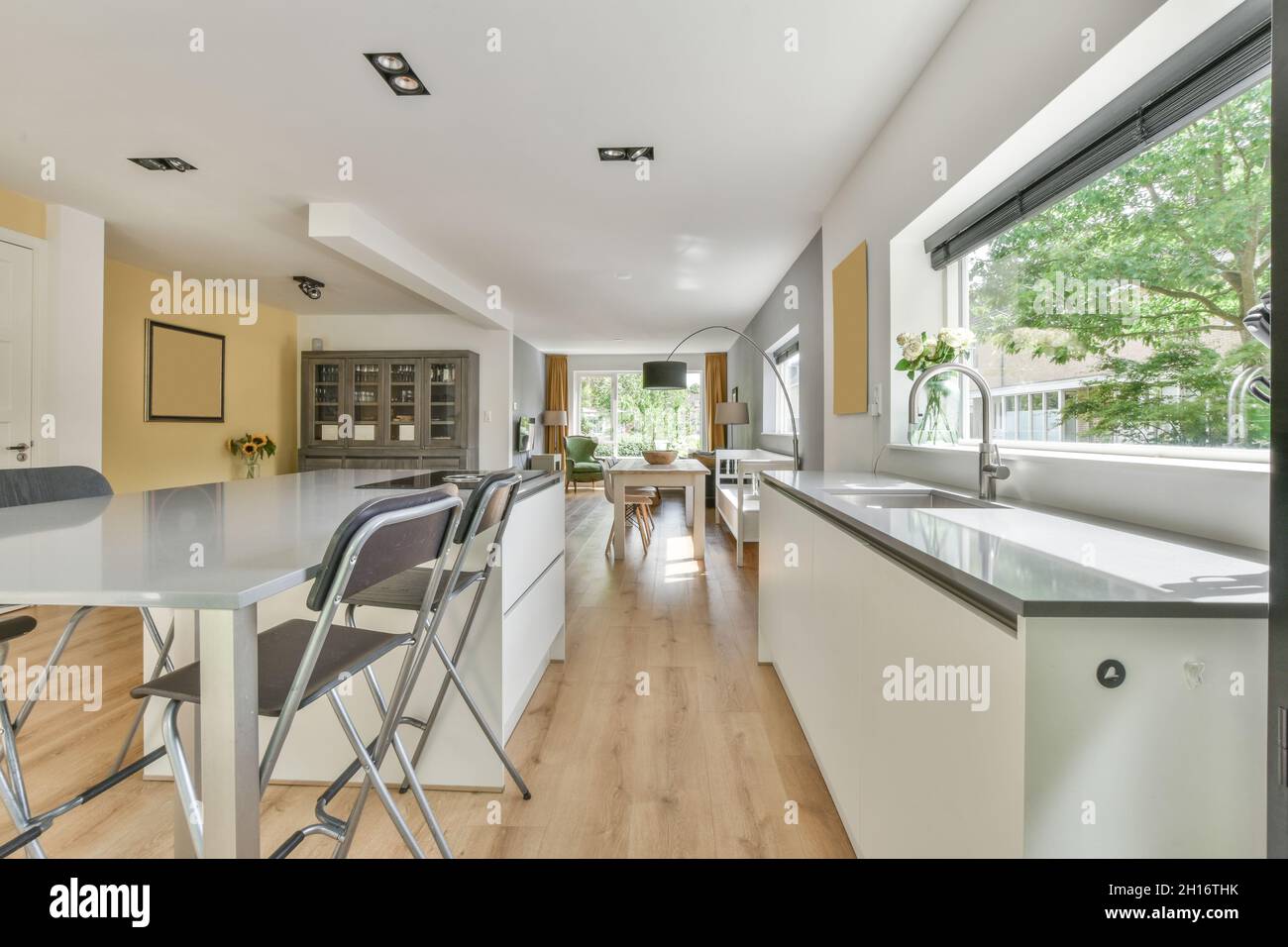 Kitchen counter with chairs placed in spacious dining room with window ...