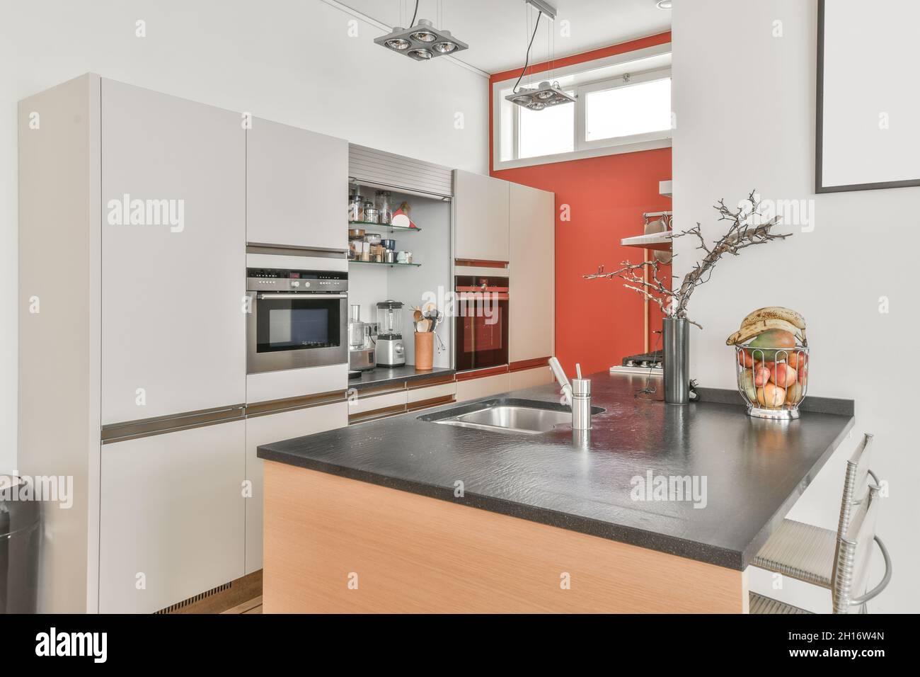 Island counter with undermounted sink in stylish kitchen with chrome ...