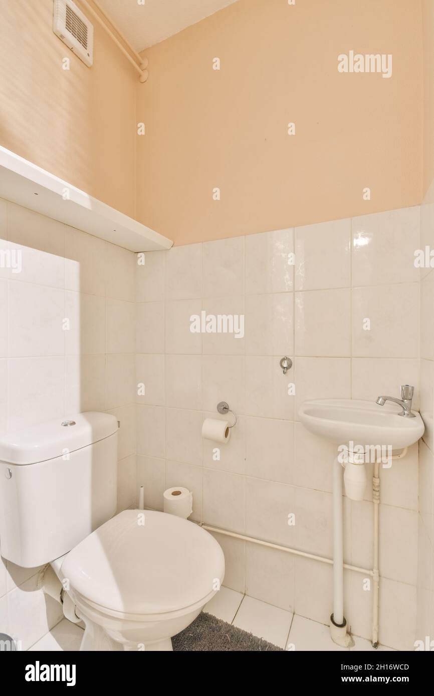 Crop interior of modern wc with yellow painted walls and white tile ...