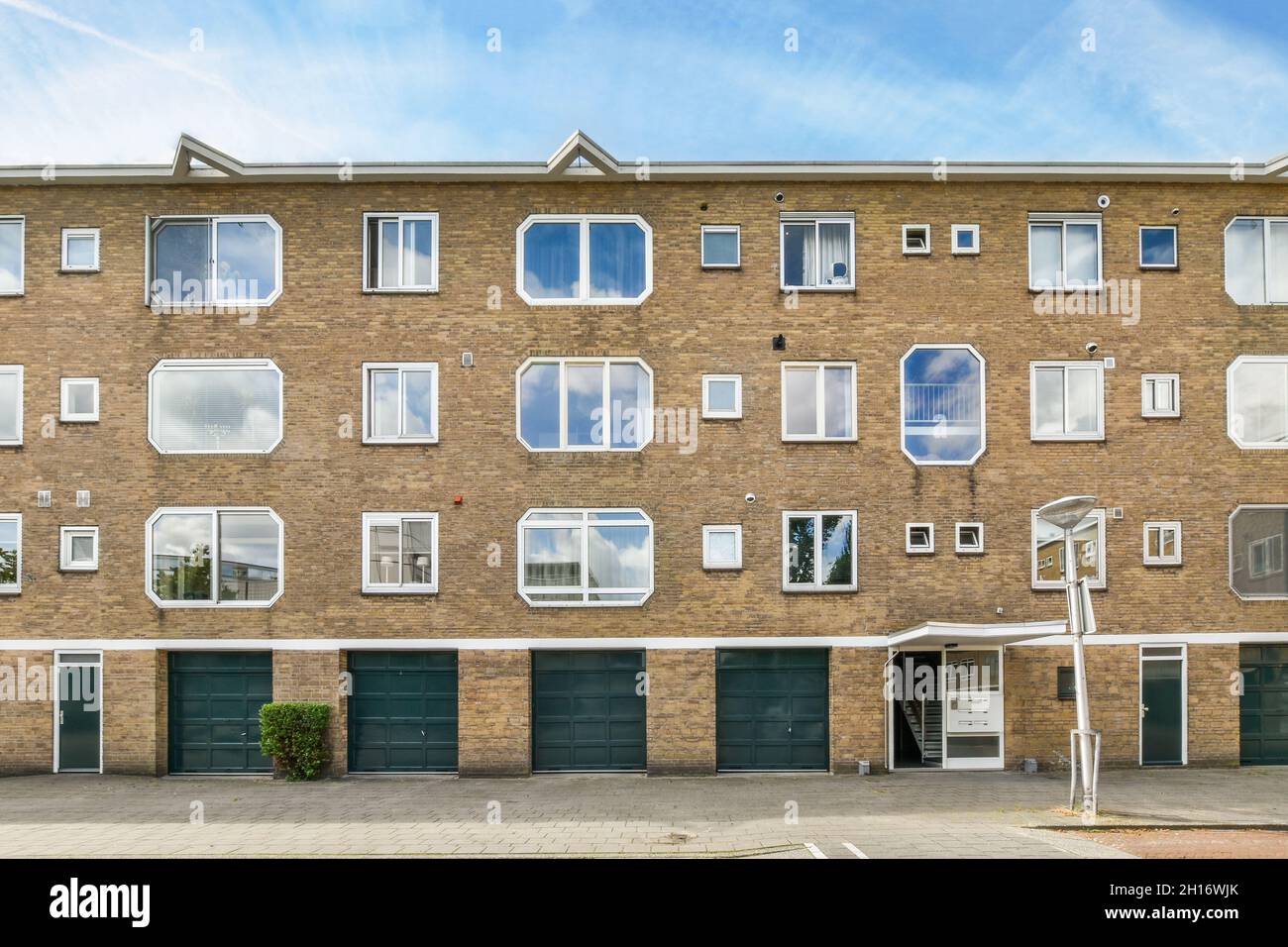 Contemporary apartment building with brick walls and windows of various ...