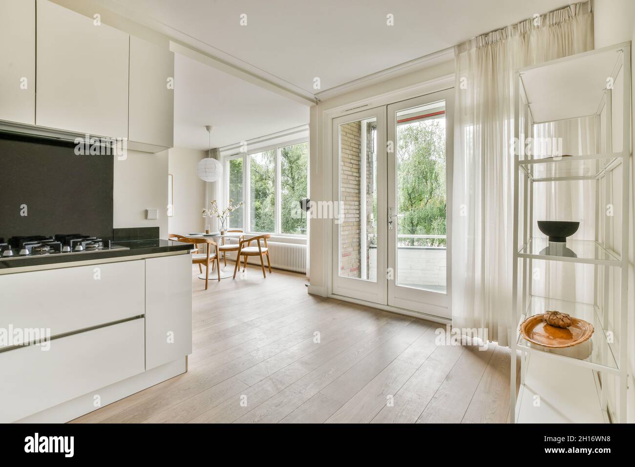 Simple white cupboards with appliances located in light modern kitchen ...