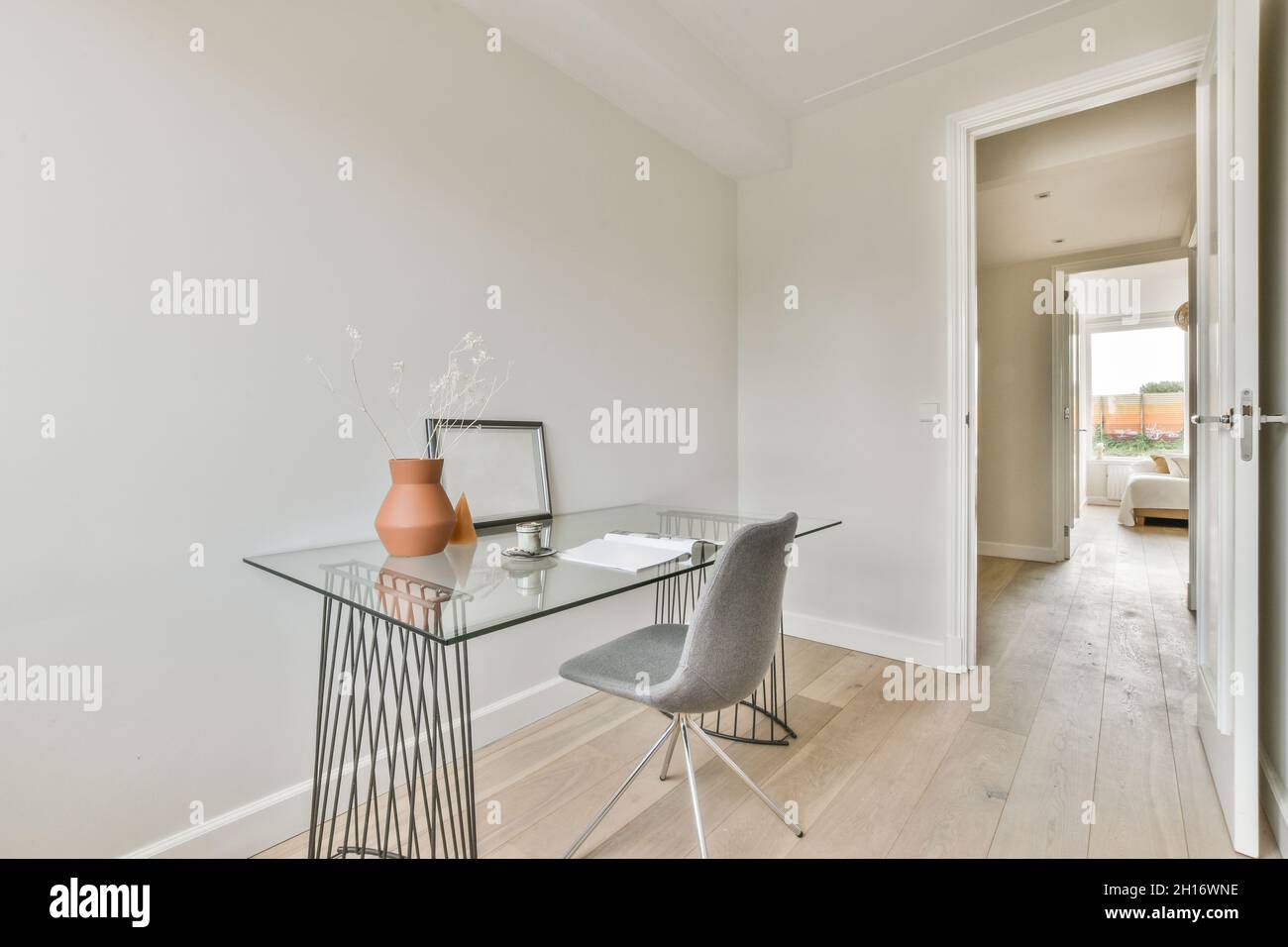 Glass table with decoration and chair located near window with curtain ...