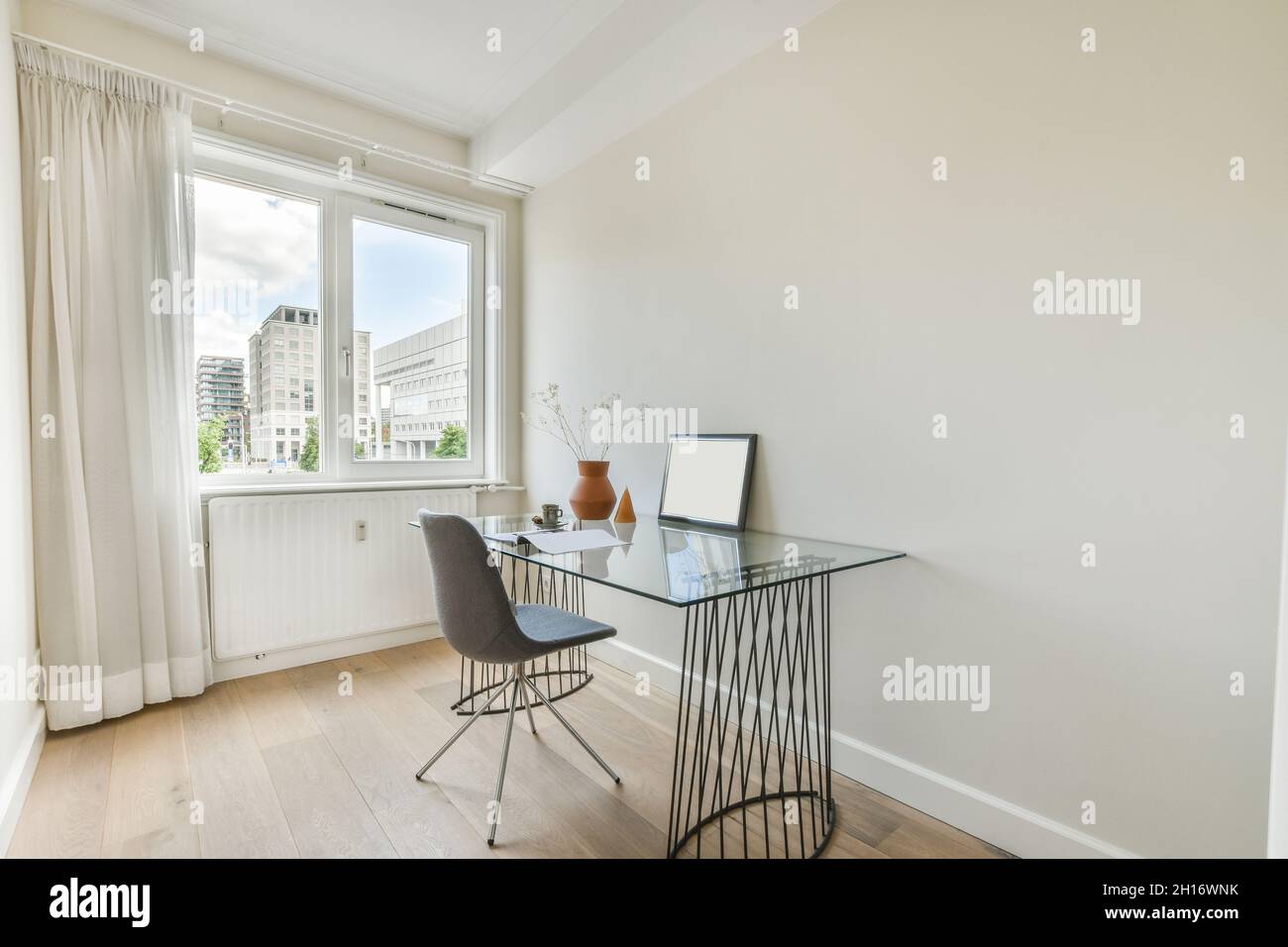 Glass table with decoration and chair located near window with curtain ...