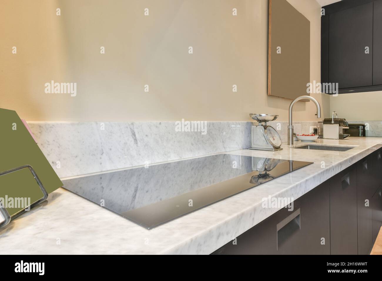 Contemporary kitchen interior with hob against tap and scales on table ...
