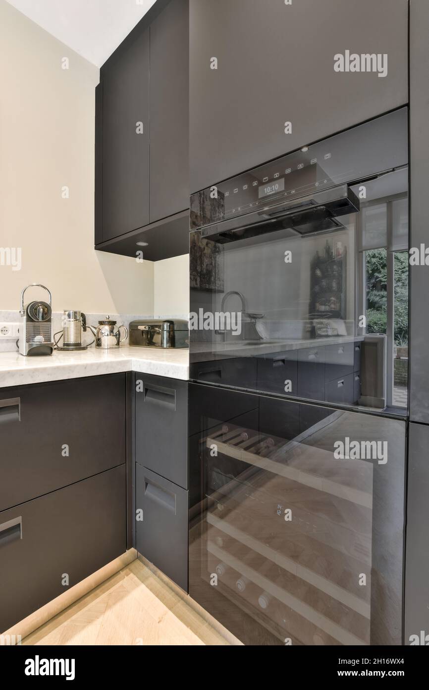 Creative design of kitchen with electric oven and microwave against ...