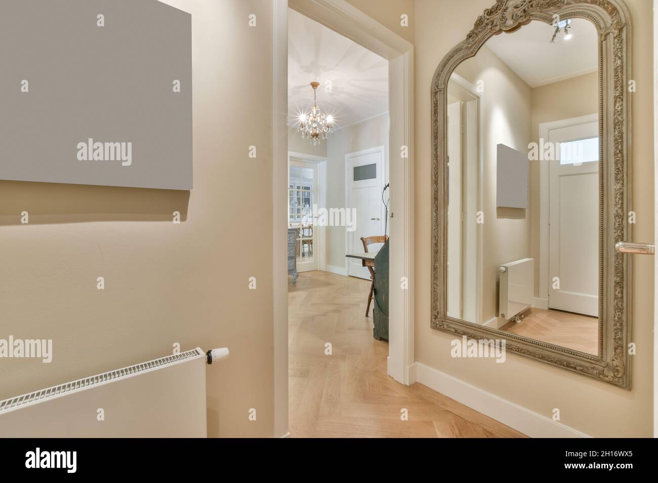 Mirror with decorative frame reflecting radiator against room with ...