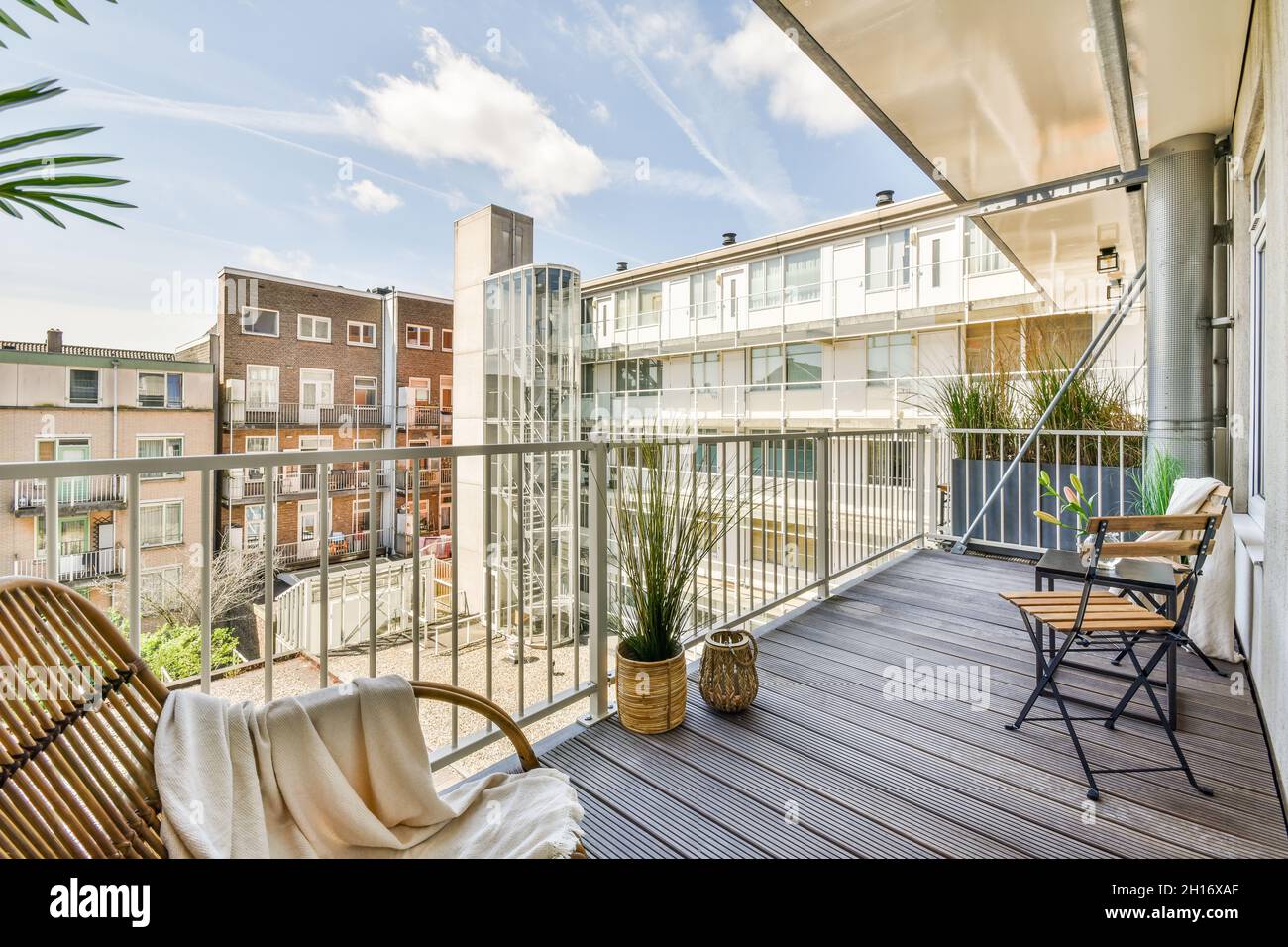 Spacious wooden terrace with comfortable chairs and potted plants in ...