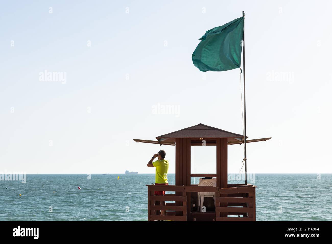 Side view of looking through binoculars on wooden watchtower while ...