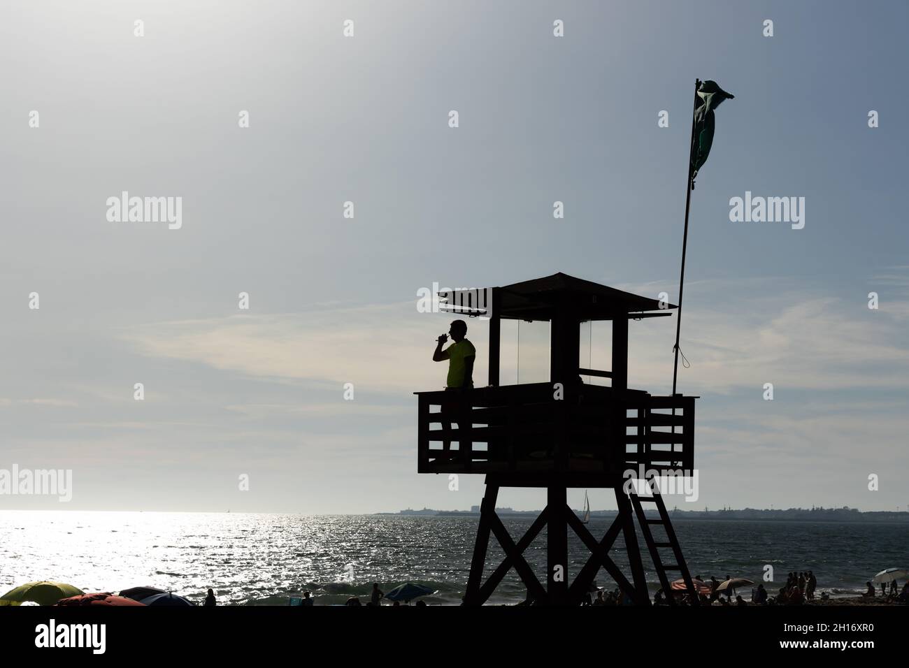 Side view of lifeguard speaking on walkie talkie radio wooden ...