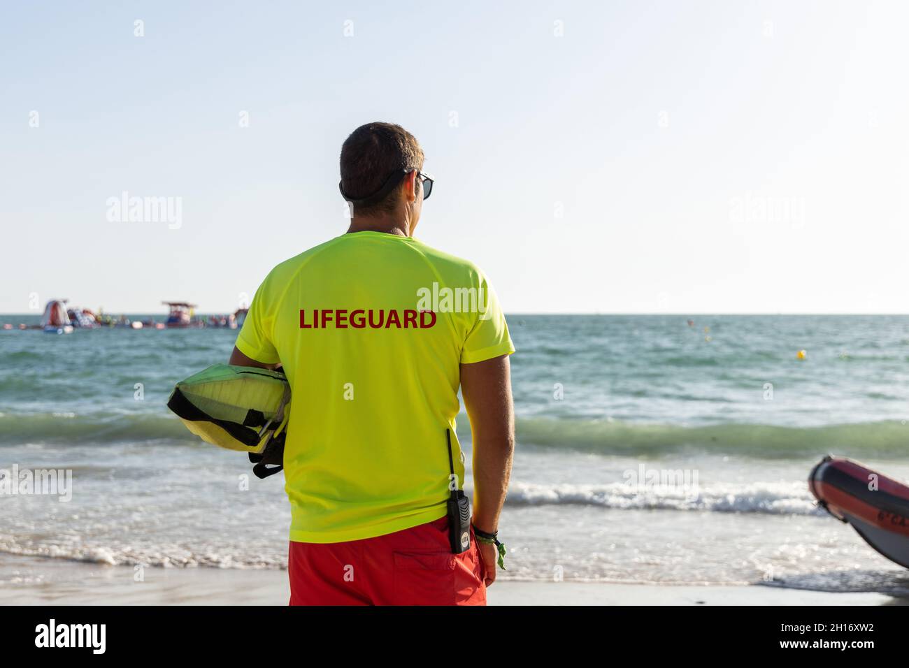 Back view of anonymous male lifeguard in shorts and t shirt and ...