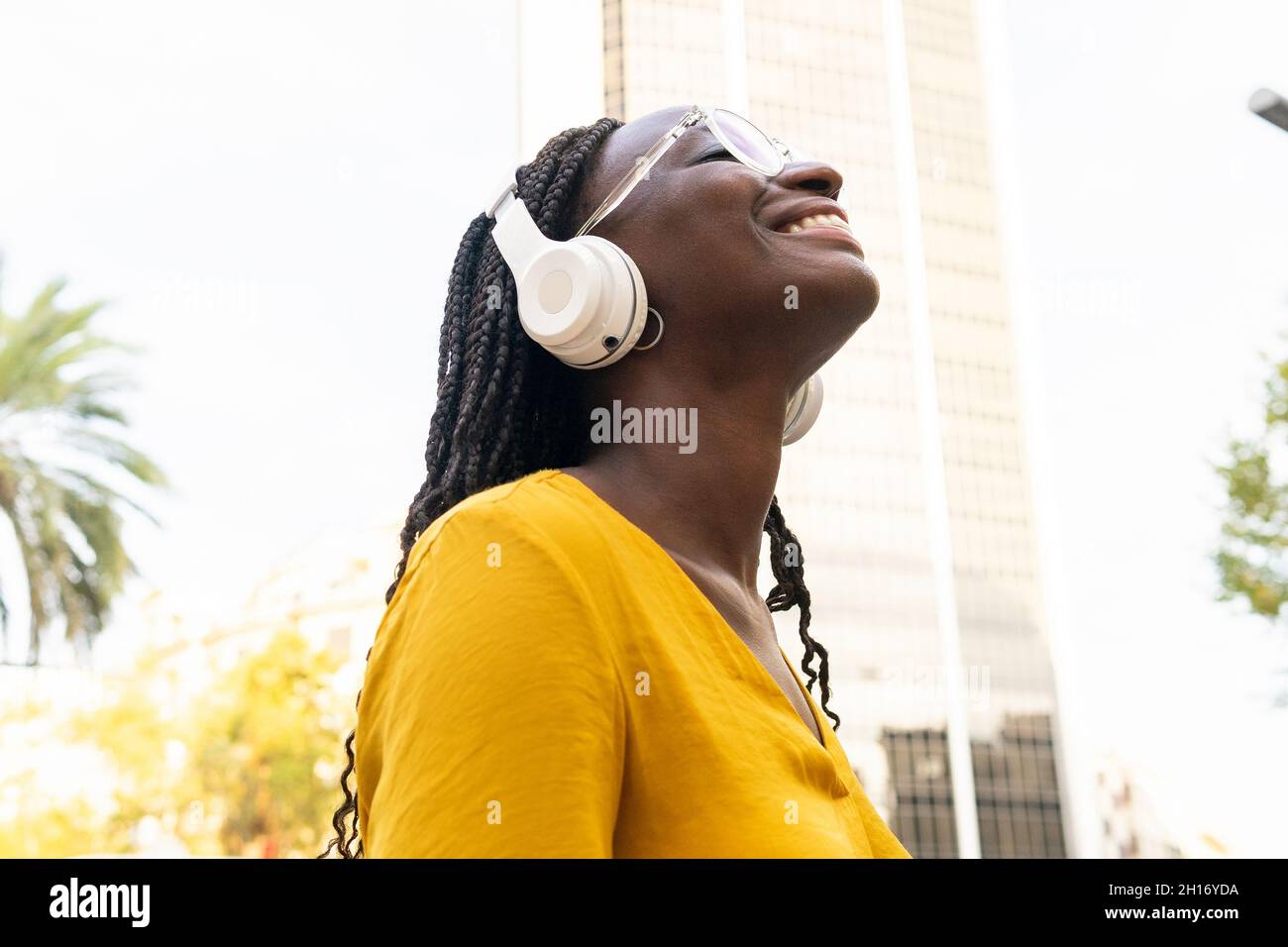 Side view of delighted African American female meloman listening to ...