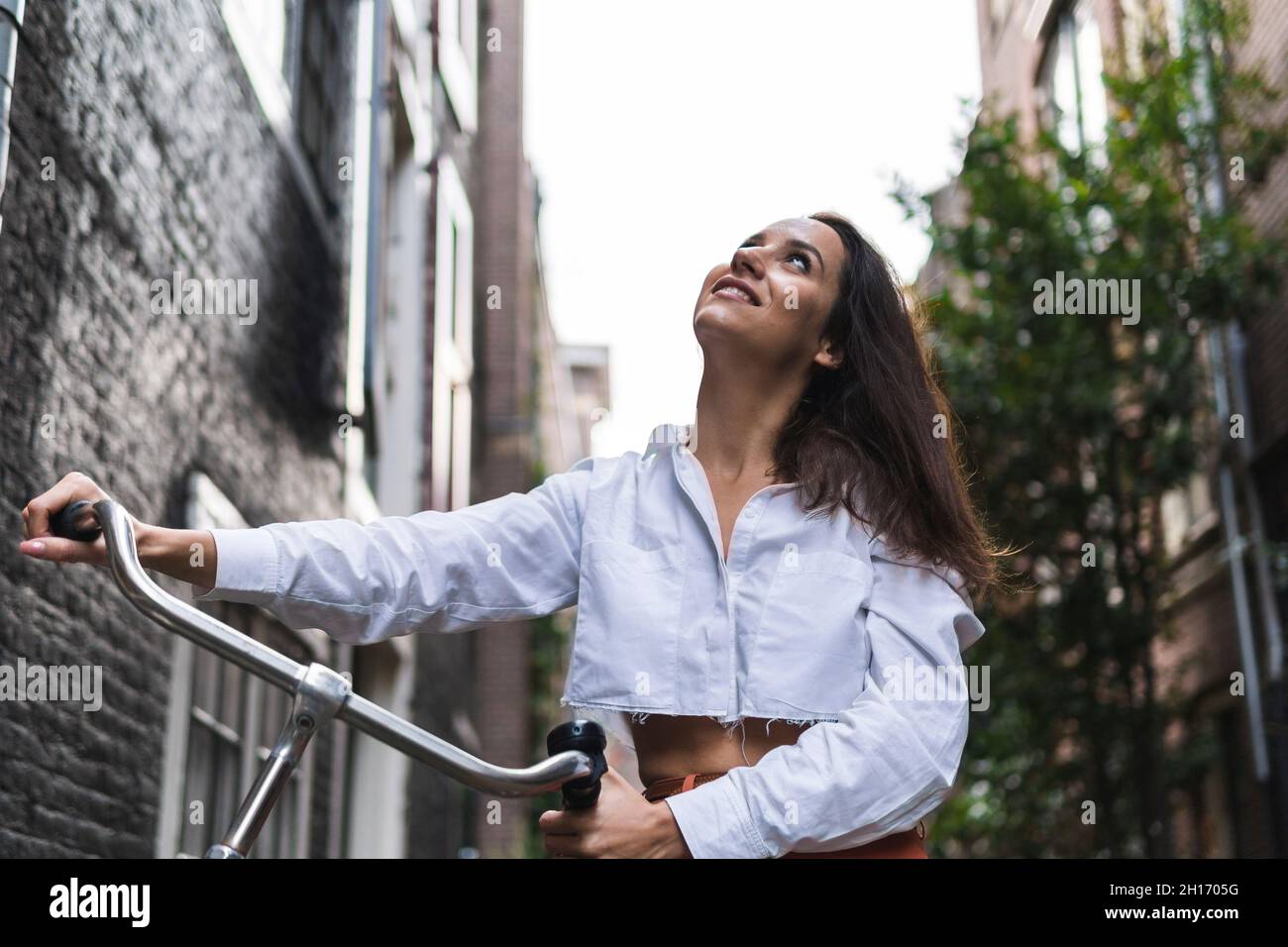 Positive transgender male with colorful flag standing on coast with ...
