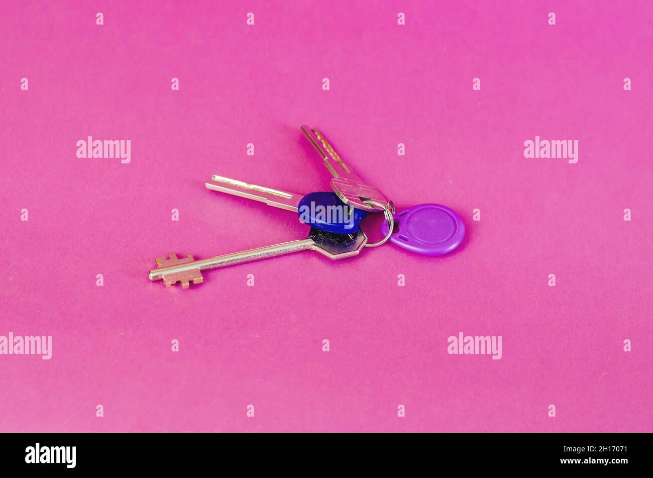 A bunch of door keys on a colored background. Three keys to the new ...