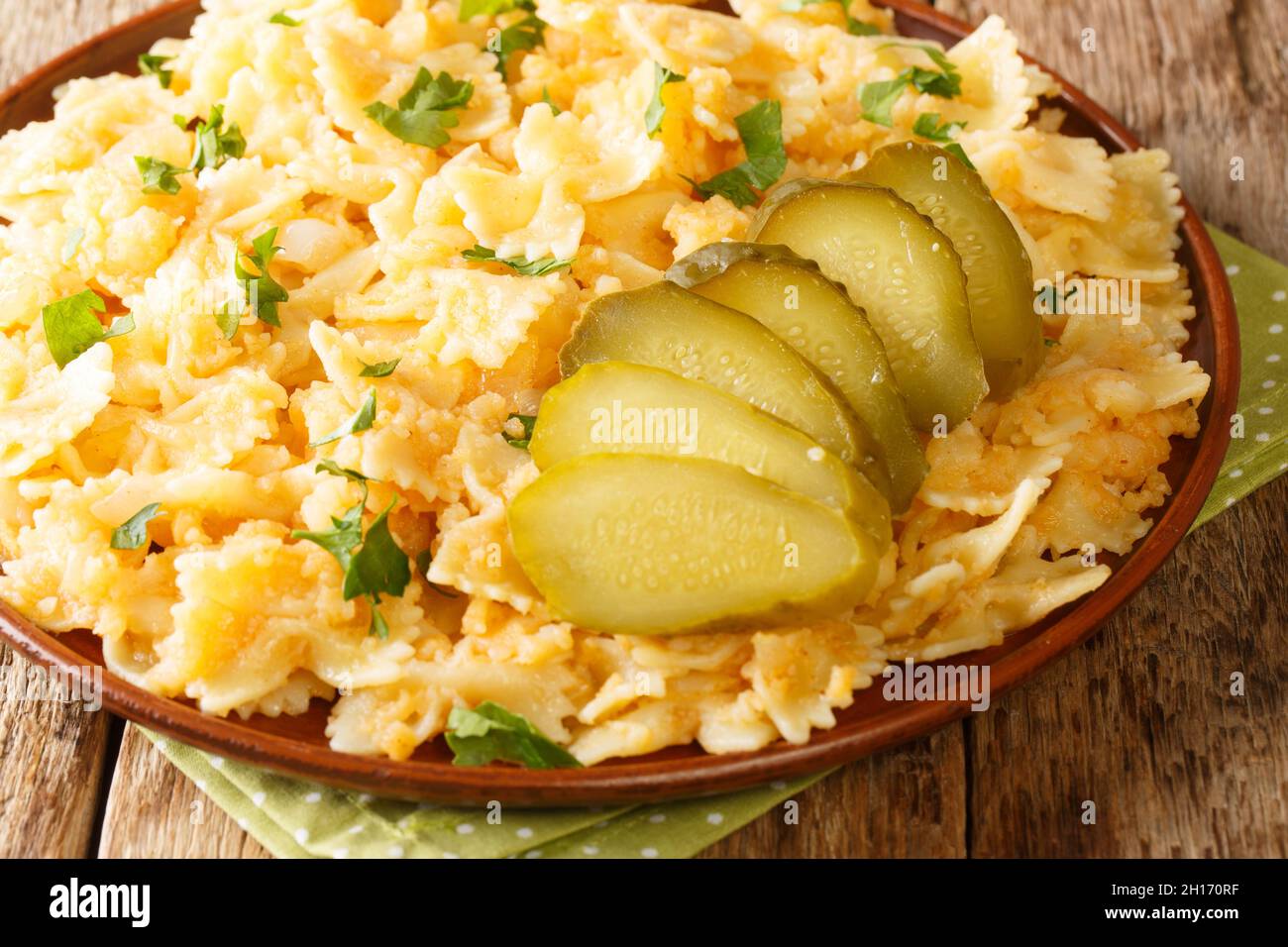 European food Pasta with potatoes and onions served with pickles close ...